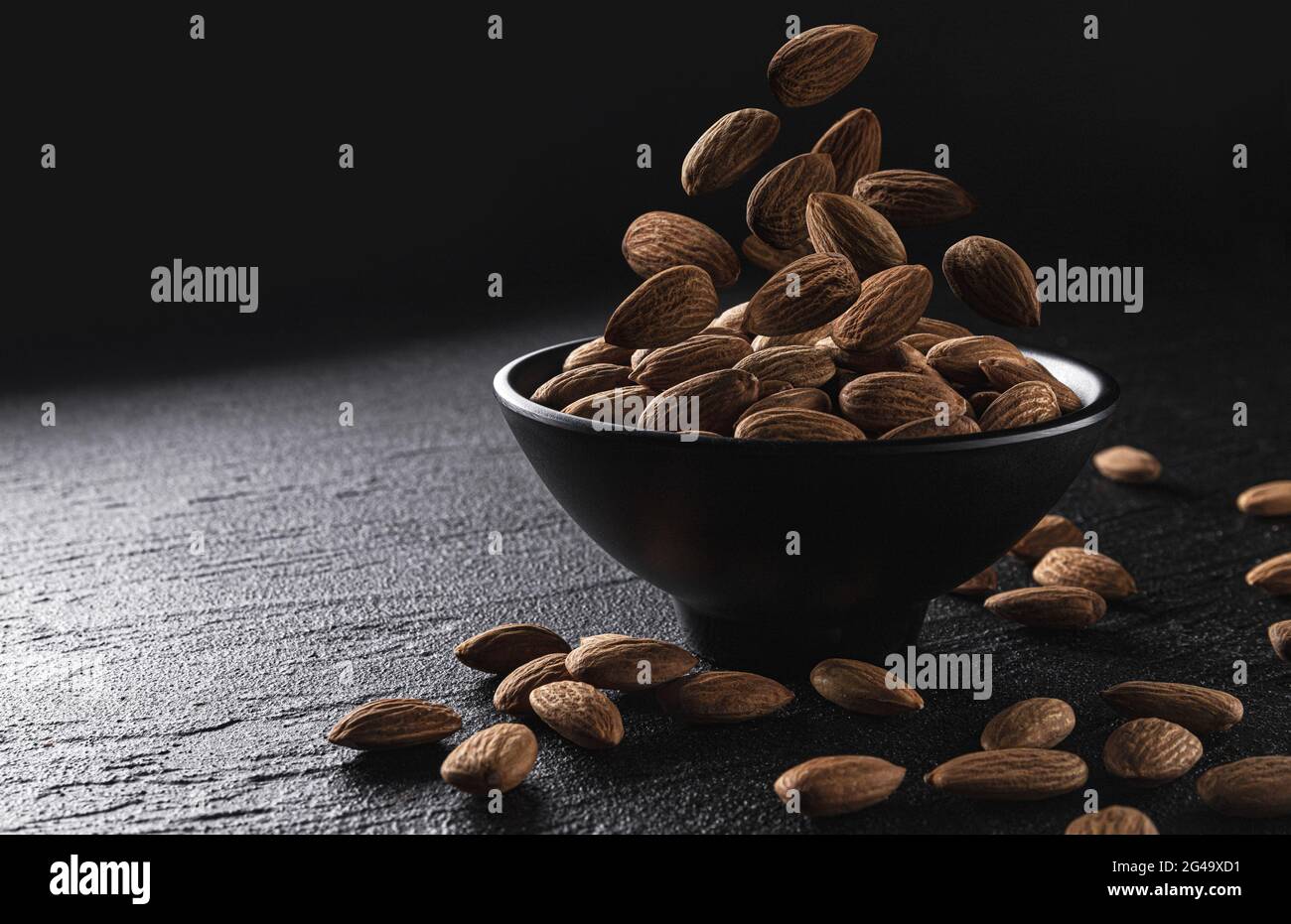 Falling almond nuts on black background with copy space Stock Photo - Alamy