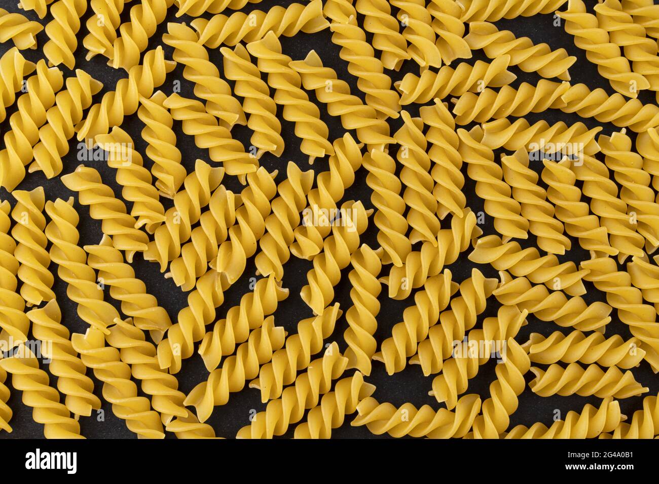 Fusilli pattern on black background, top view, flat lay texture Stock ...