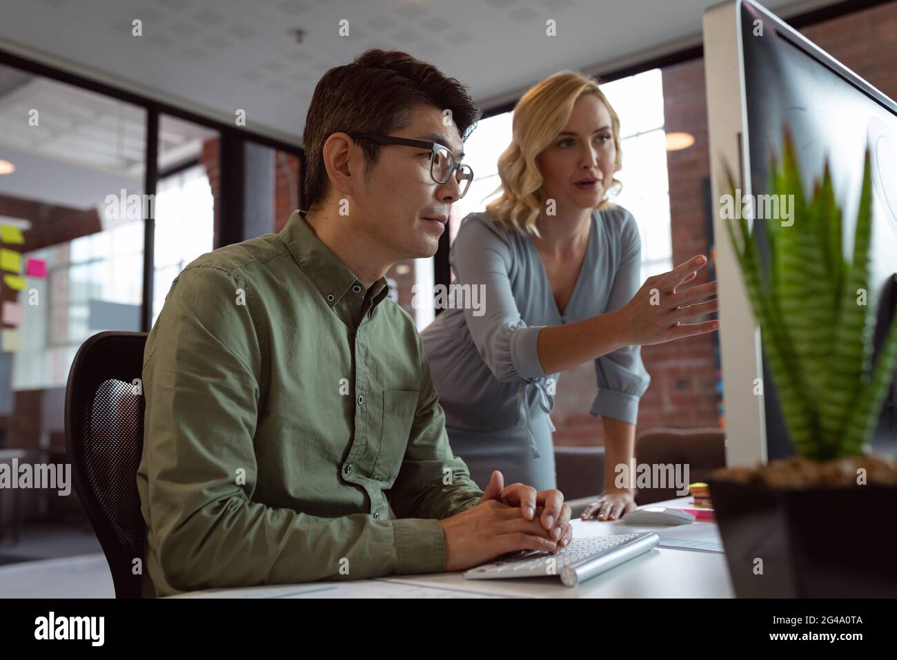 Diverse male and female colleague looking at computer screen and ...