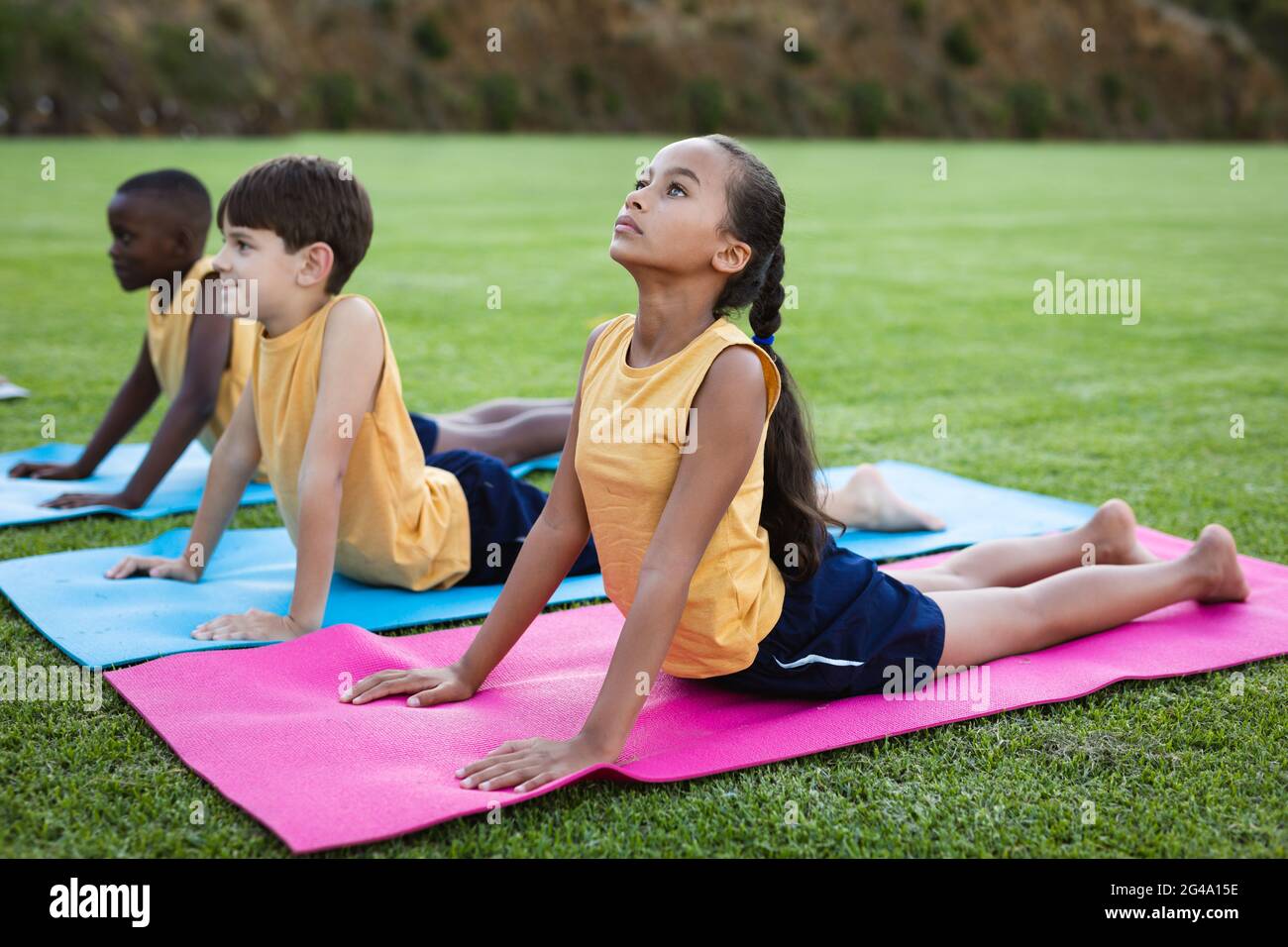 Group of diverse students performing stretching exercise in the garden ...