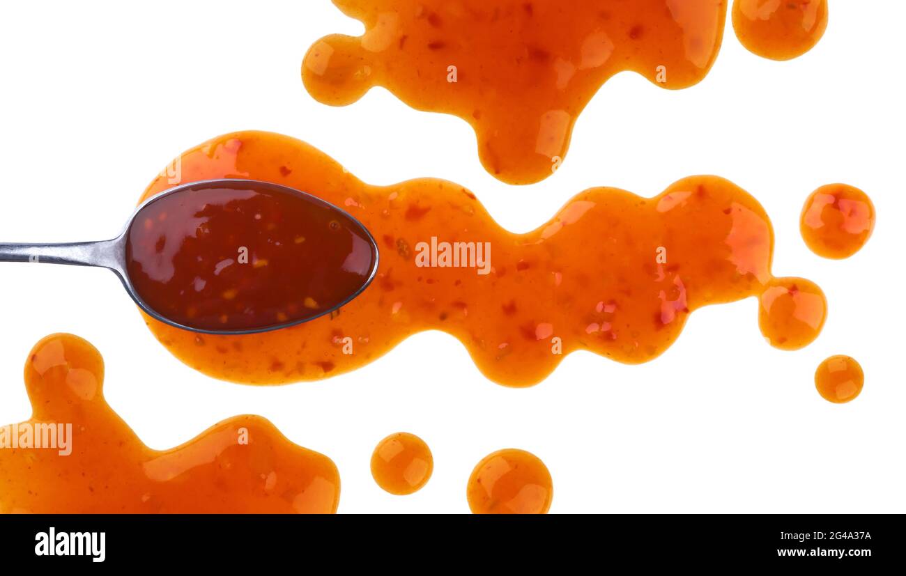 Splach of sweet and sour sauce with spoon isolated on white background ...