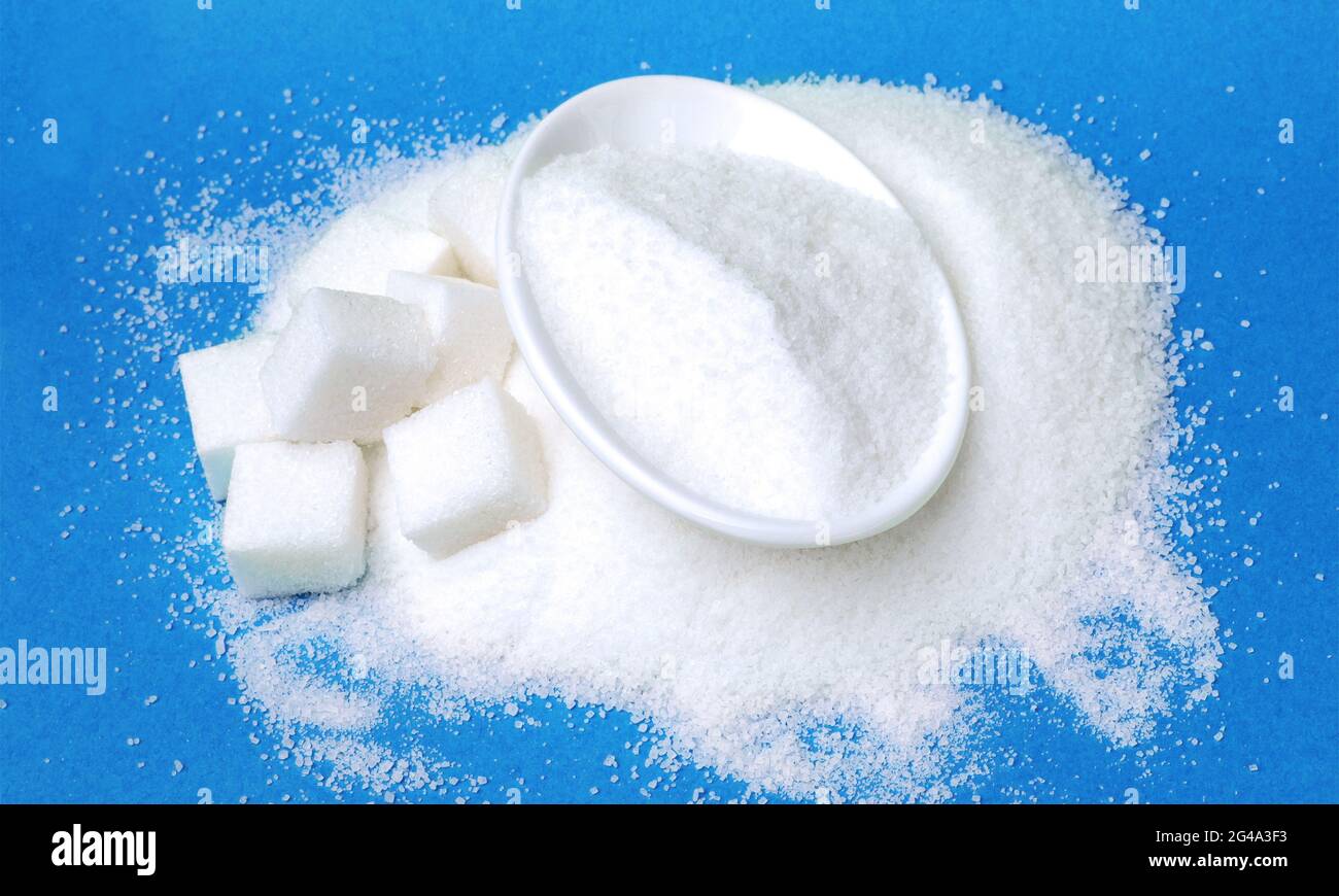Granulated and lump sugar on blue background Stock Photo - Alamy