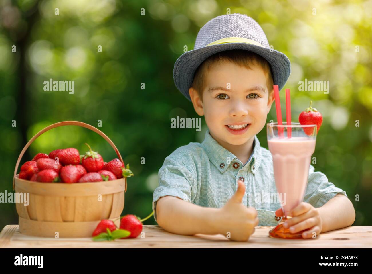 little boy holding glass of strawberry milkshake outdoors Stock Photo ...