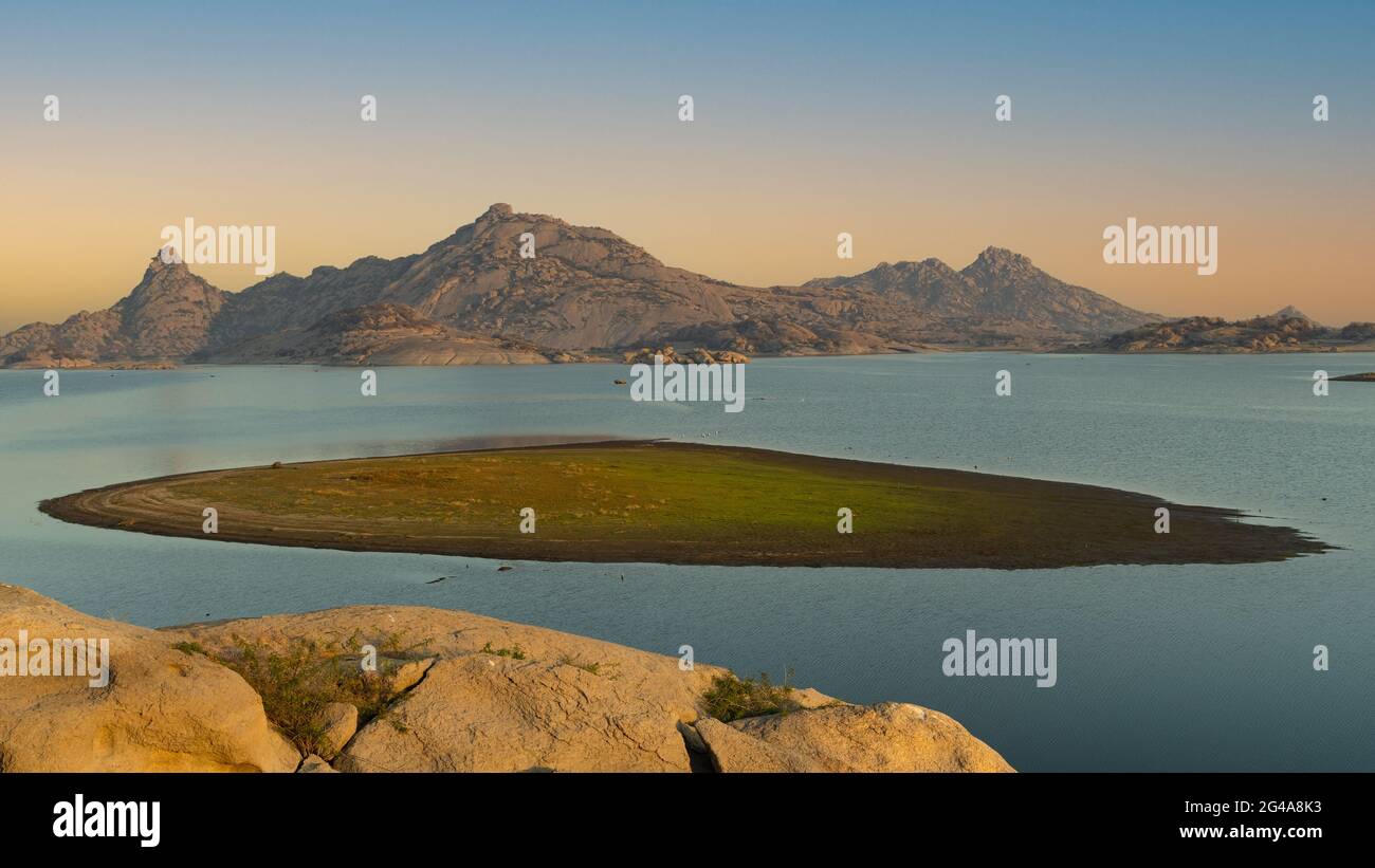 A View during an early morning glow of a small green island in the ...