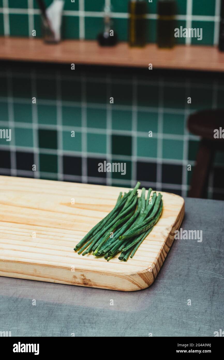 A vertical shot of fresh green onion on a wooden cutting board Stock ...