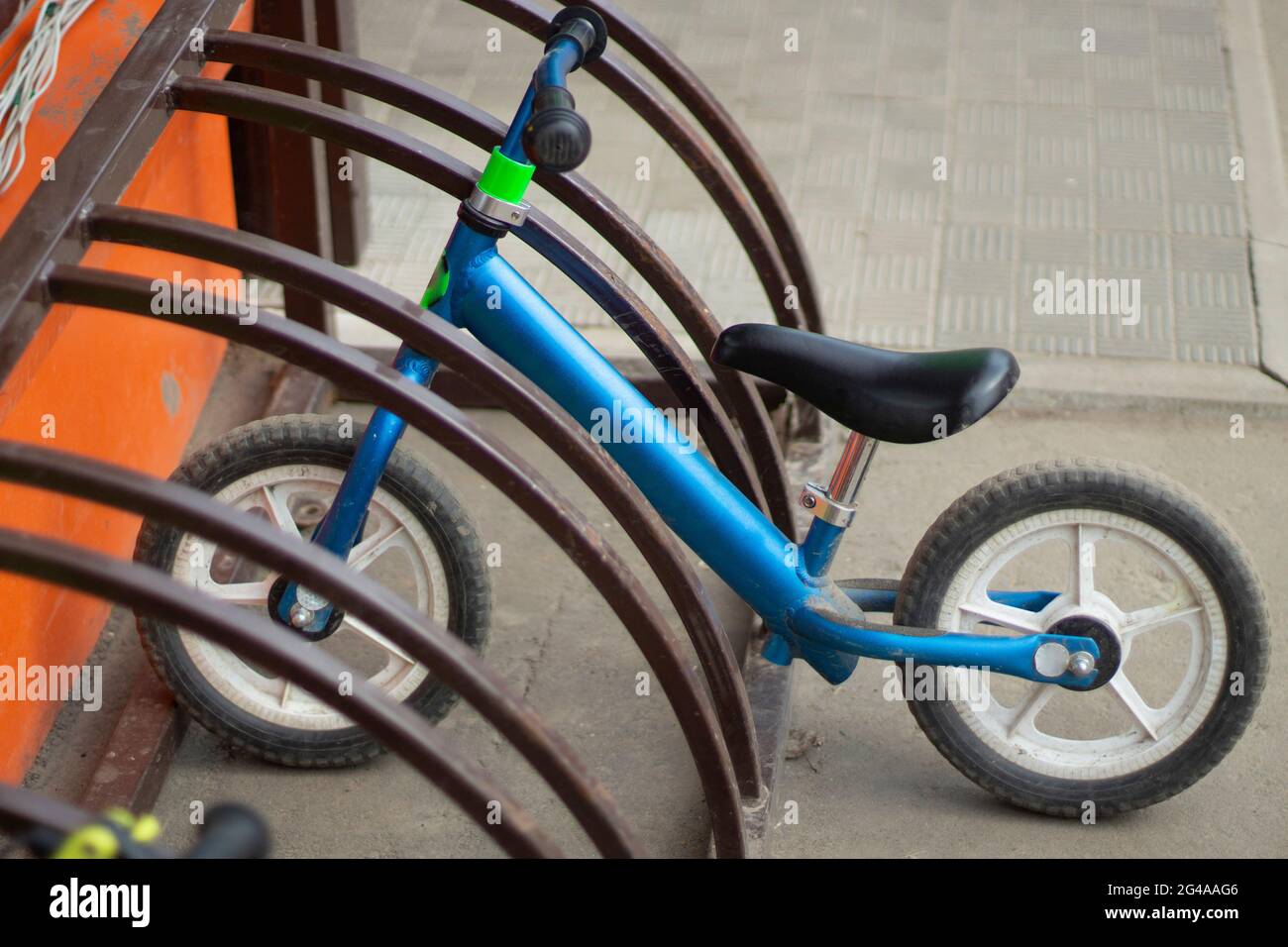 Children's bike in the bicycle parking. Bicycle without pedals ...