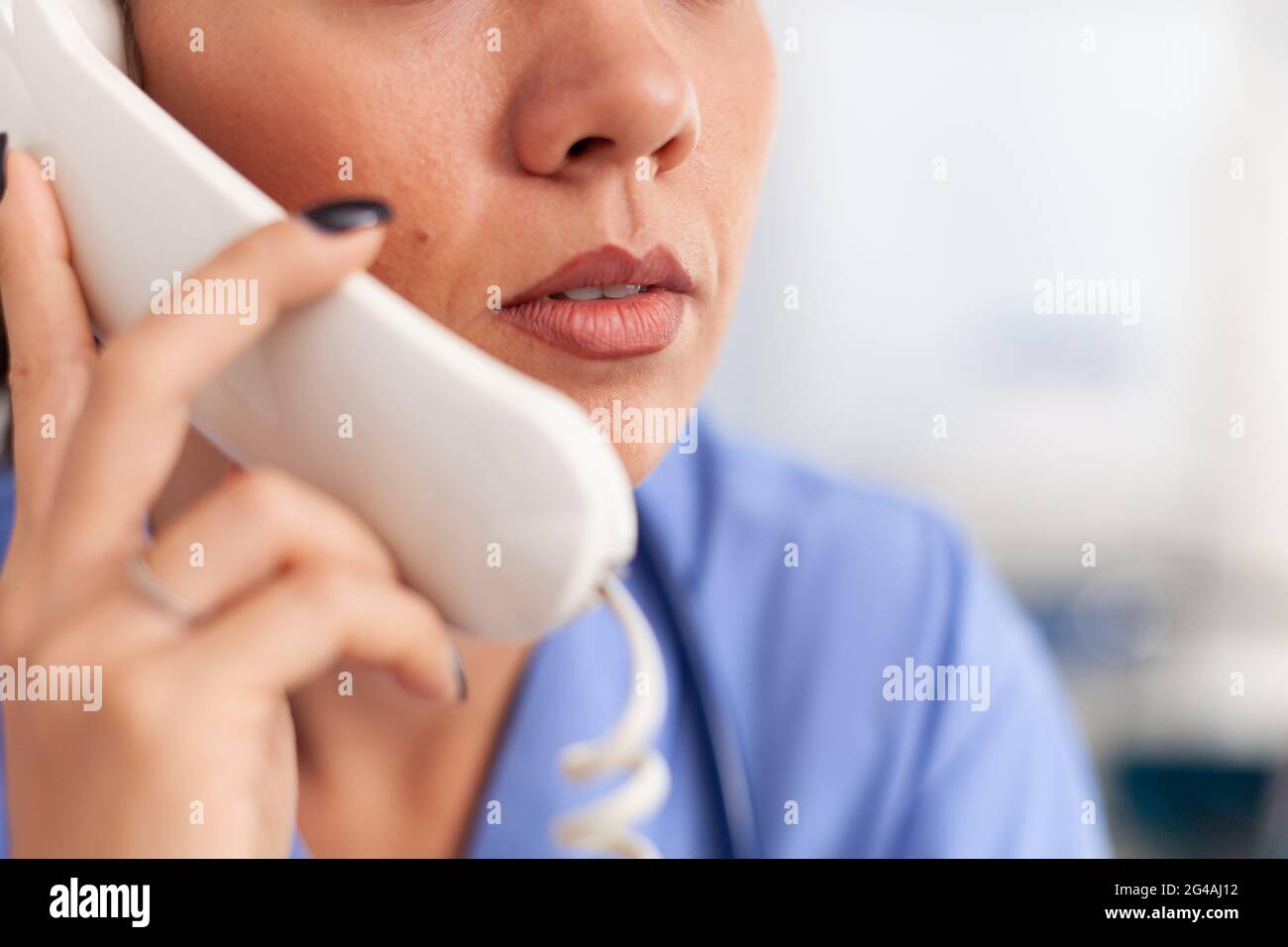 Medical receptionist answering phone calls from patient in hospital ...