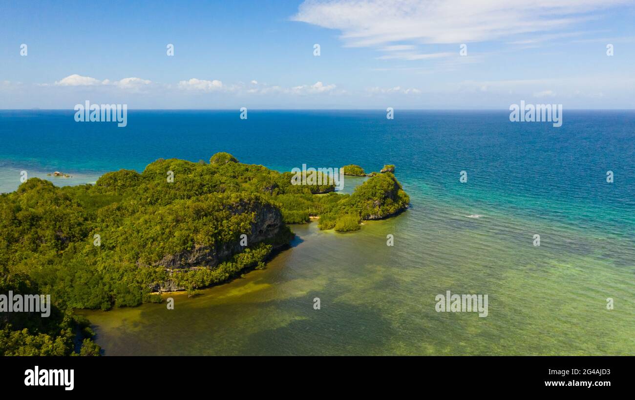 Aerial view of the mountains covered with jungle, blue sea and sky with ...