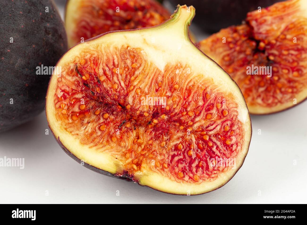 Lots of sliced figs on a white background. Harvesting berries and ...