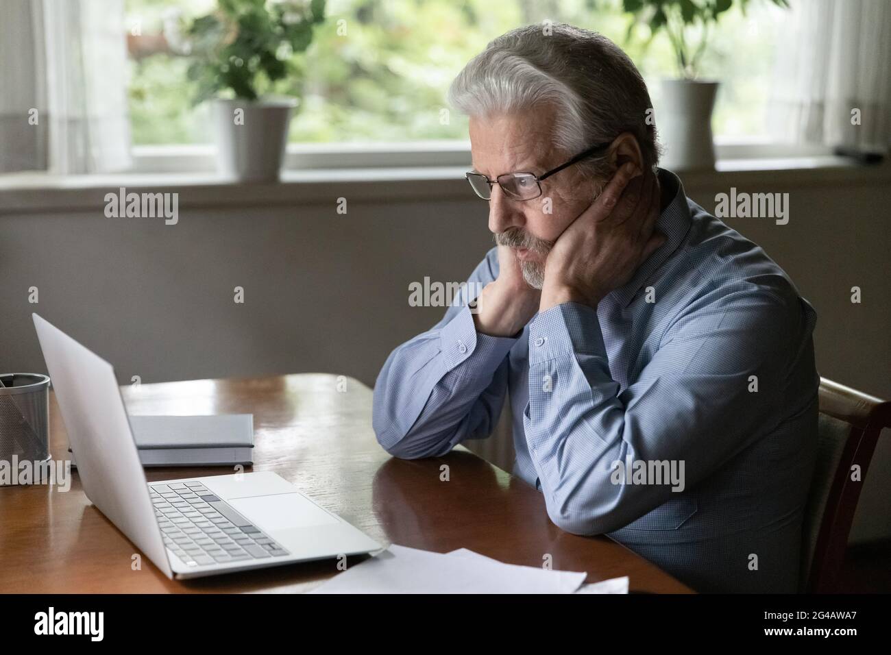 Pensive old Caucasian man work on laptop thinking Stock Photo - Alamy
