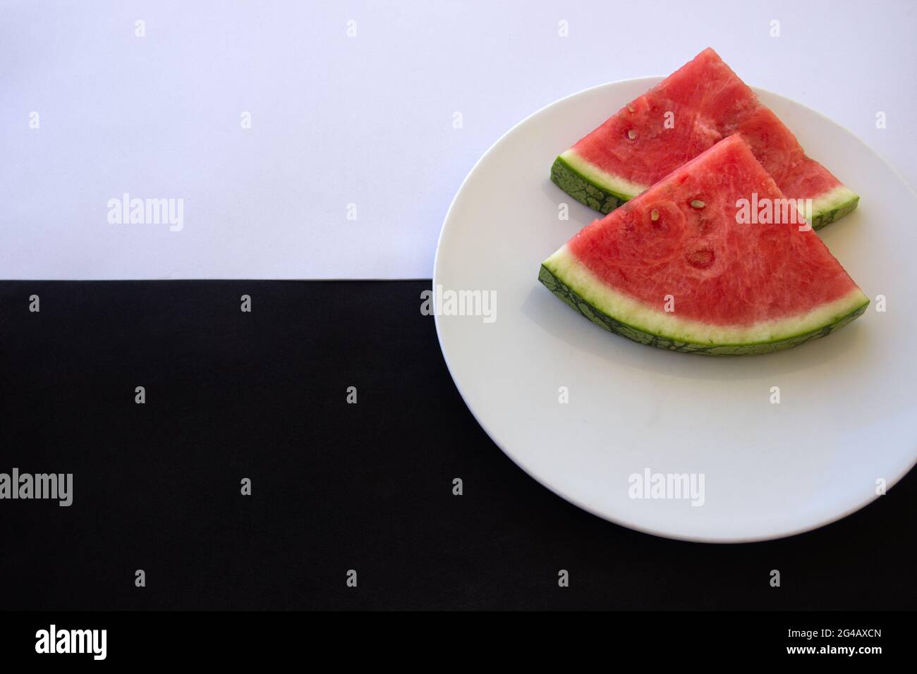 Slices of watermelon in the shape of a triangle on a black and white ...