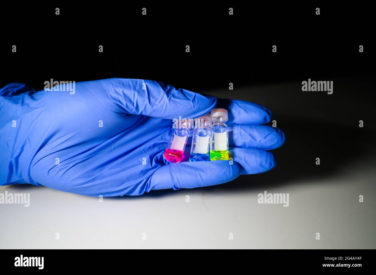 Scientist holding Three colourful liquid in different LCMS glass vial ...