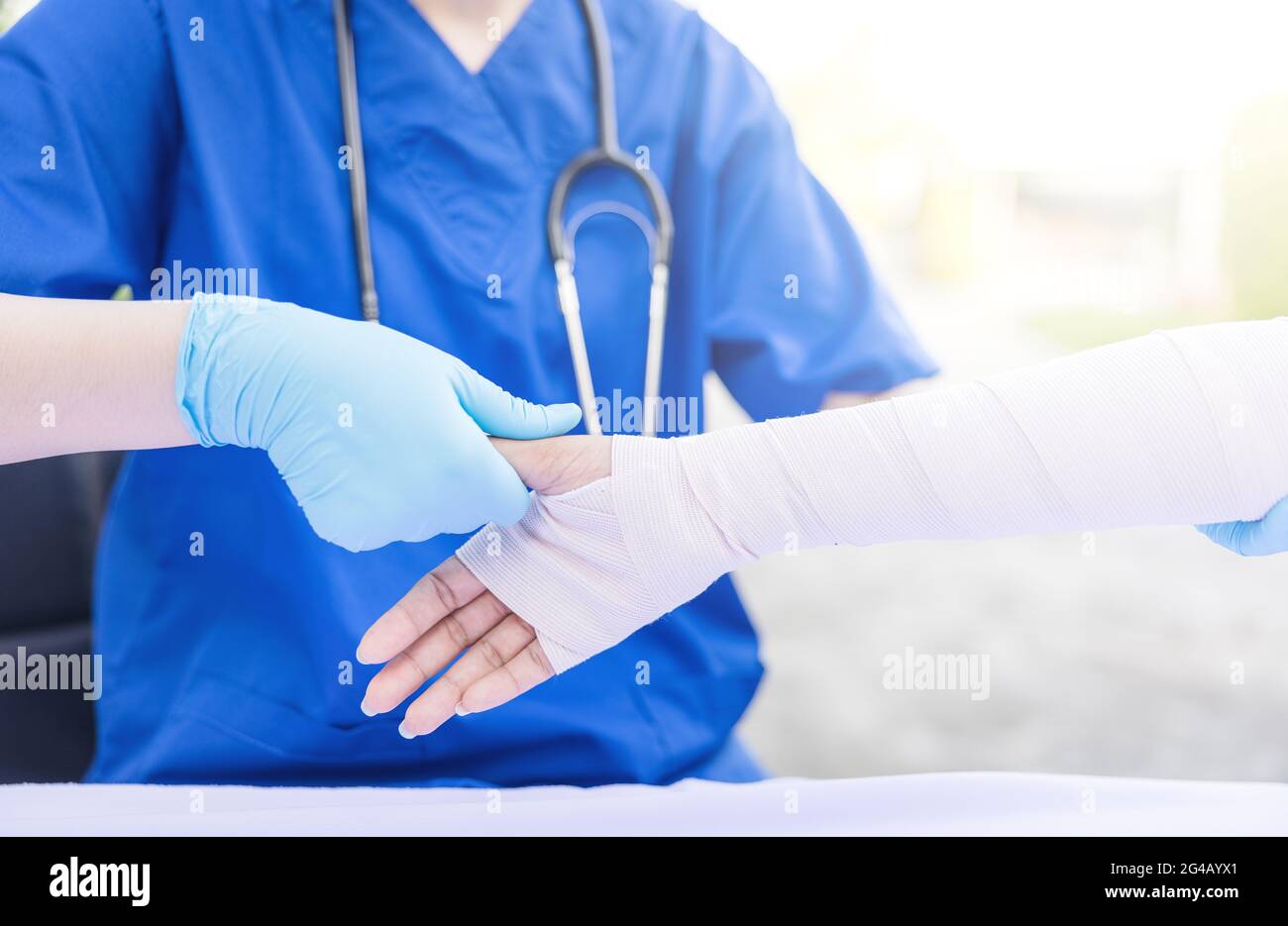 Close-up of female doctor putting a bandage on injured hand upper limb ...