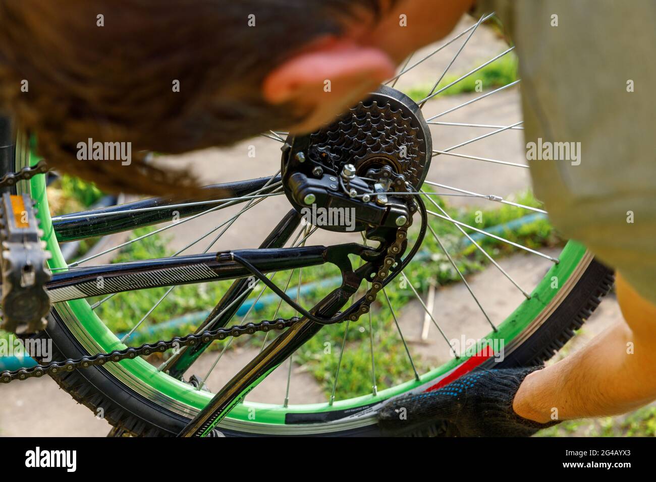 Bike mechanic man repairs bicycle in bicycle repair shop, outdoor. Hand ...