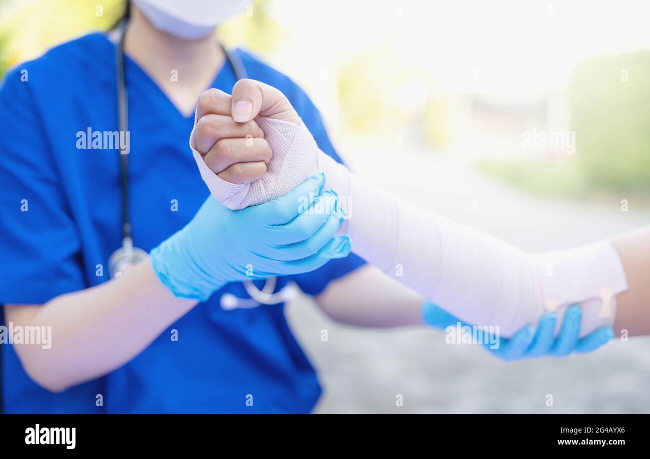 Close-up of female doctor putting a bandage on injured hand upper limb ...
