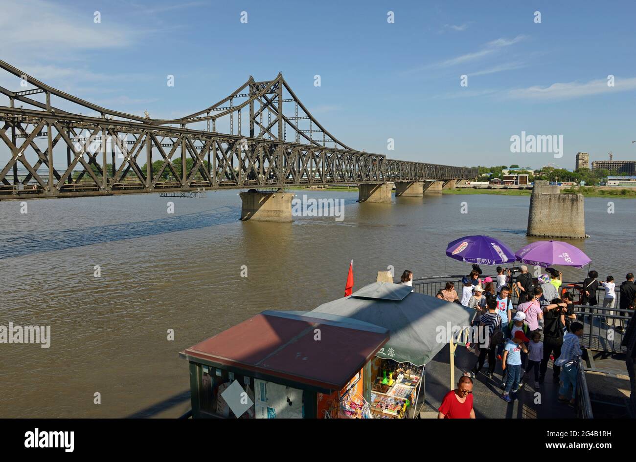 Tourists on the damaged old bridge admire the newer Sino-Korea ...