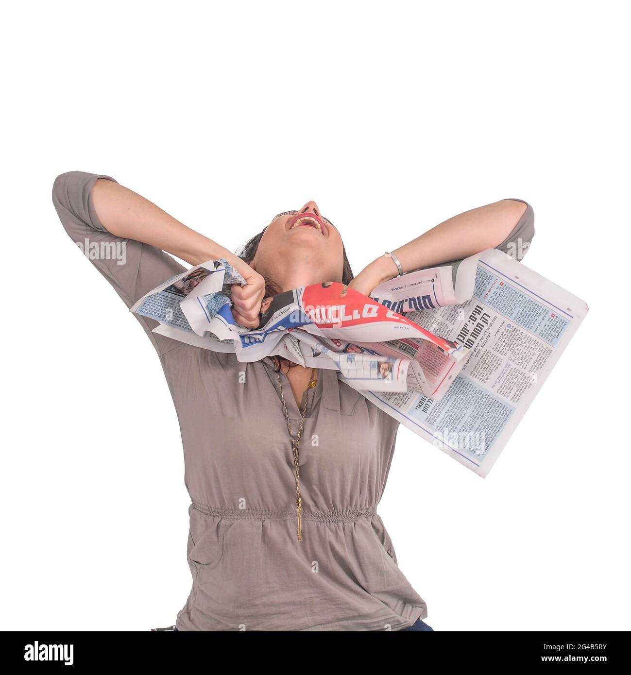 excited and emotional young woman ripping up a printed newspaper studio ...