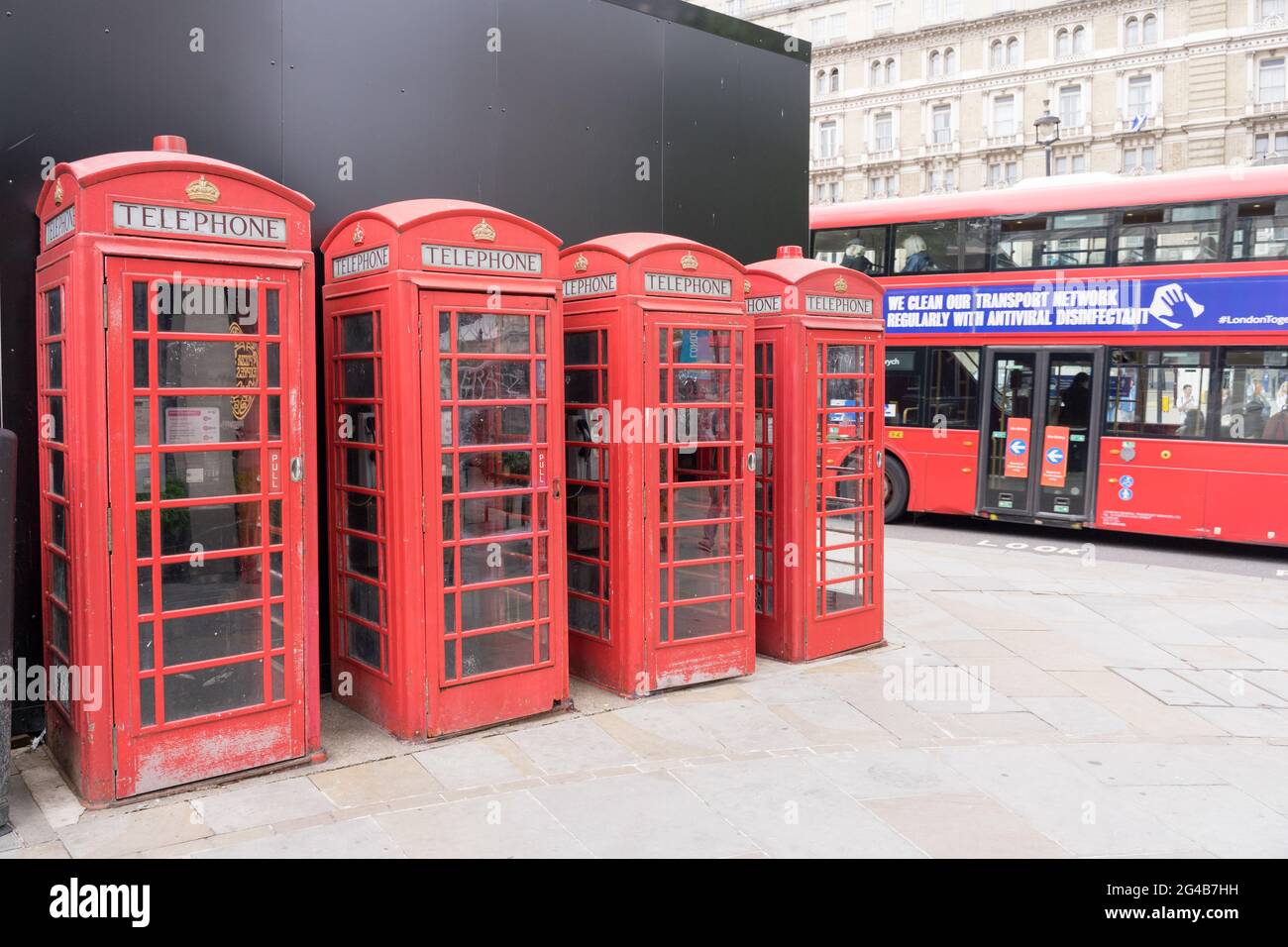 row of Four red British cast iron telephone boxes , London red bus in ...