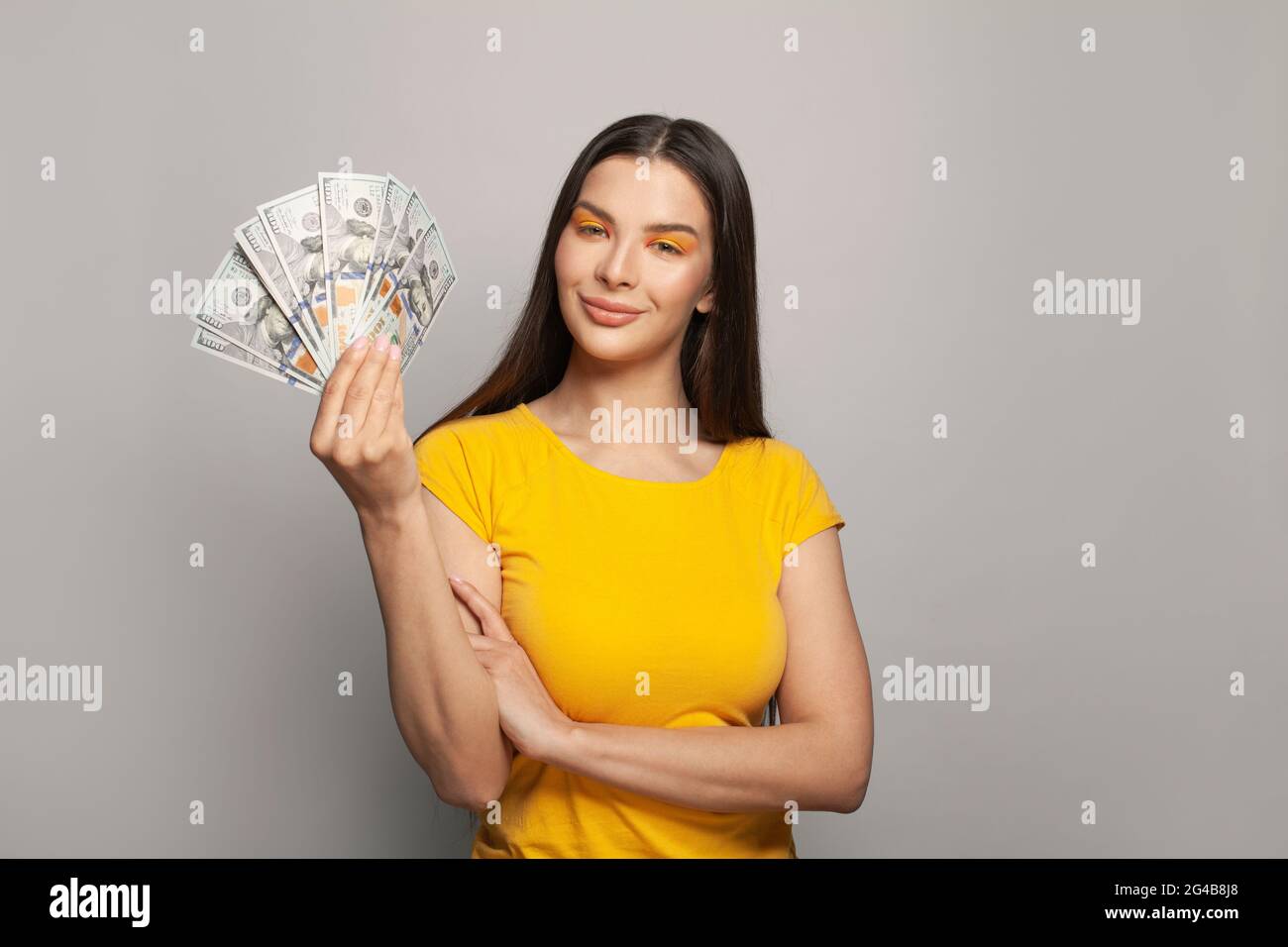 Happy beautiful woman holding American dollars cash money on white ...