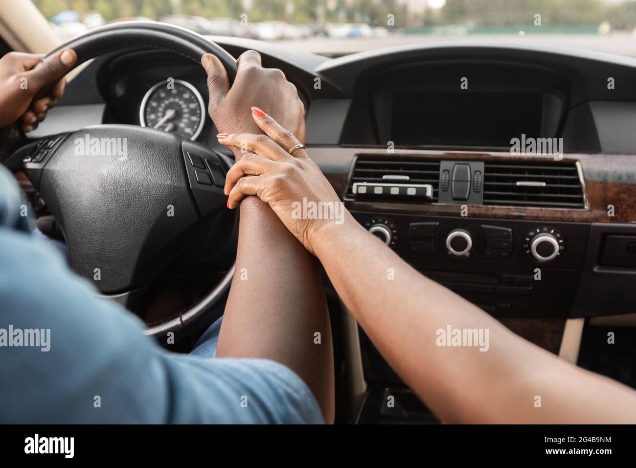Unrecognizable black lady touching husband driving car hand Stock Photo ...