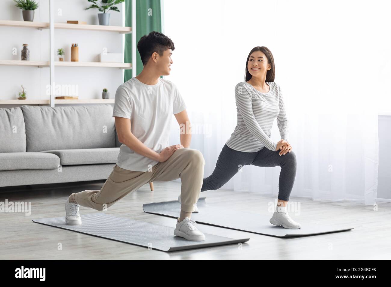 Happy asian couple exercising at home, copy space Stock Photo - Alamy