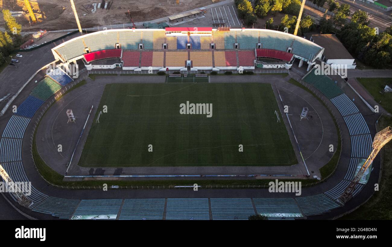 Football stadium in the city park. A green field and stands are visible ...