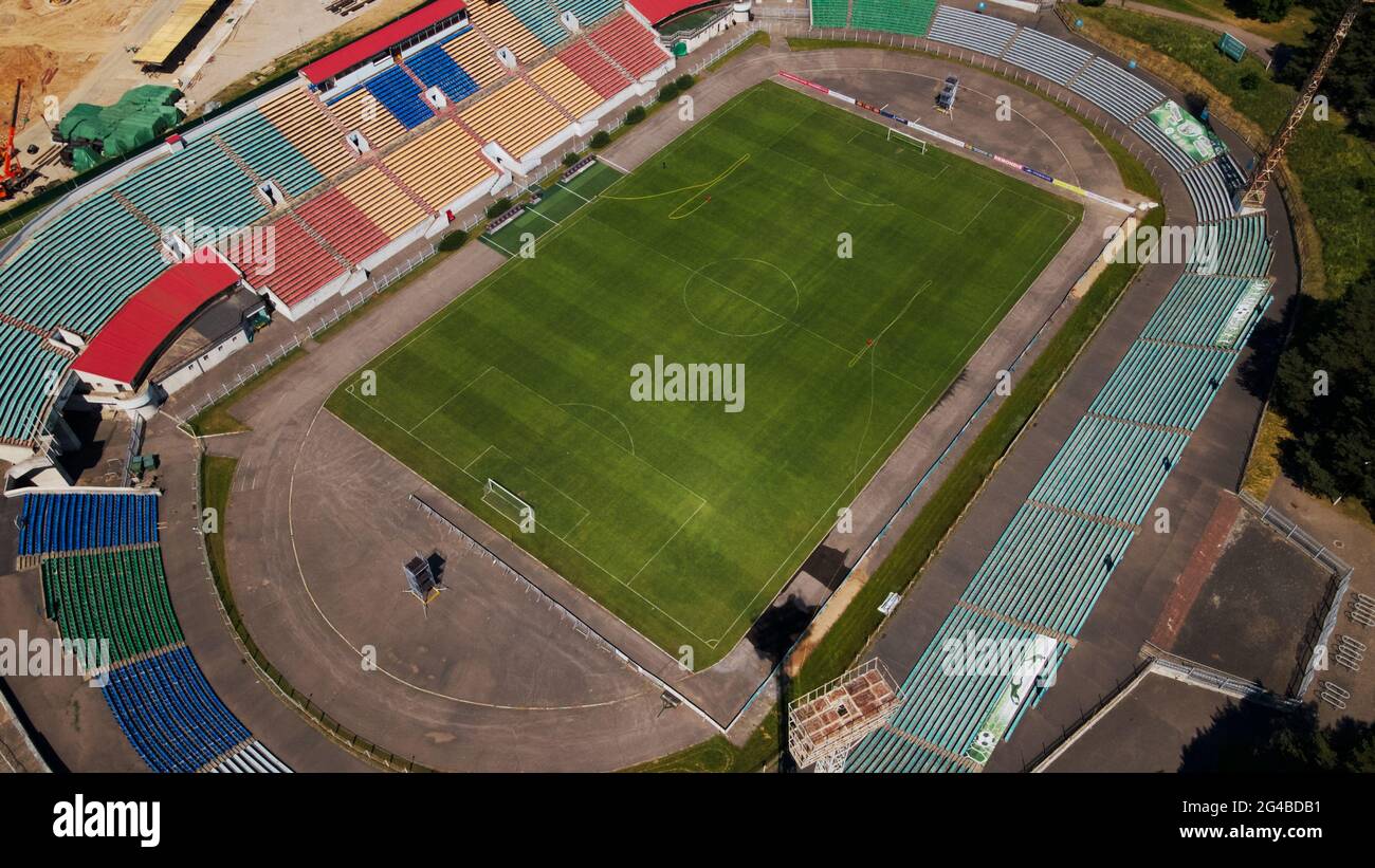 Football stadium in the city park. A green field and stands are visible ...