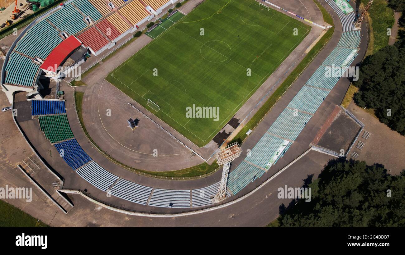 Football stadium in the city park. A green field and stands are visible ...