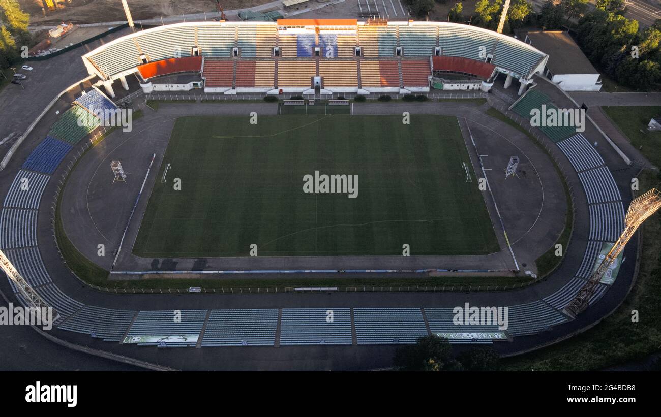 Football stadium in the city park. A green field and stands are visible ...