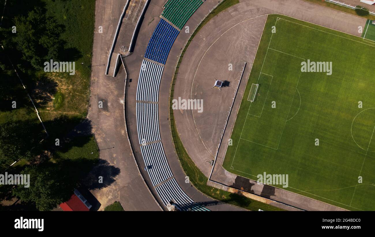 Football stadium in the city park. A green field and stands are visible ...