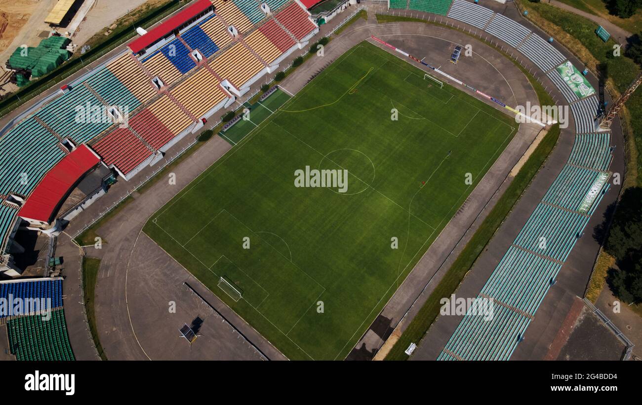 Football stadium in the city park. A green field and stands are visible ...