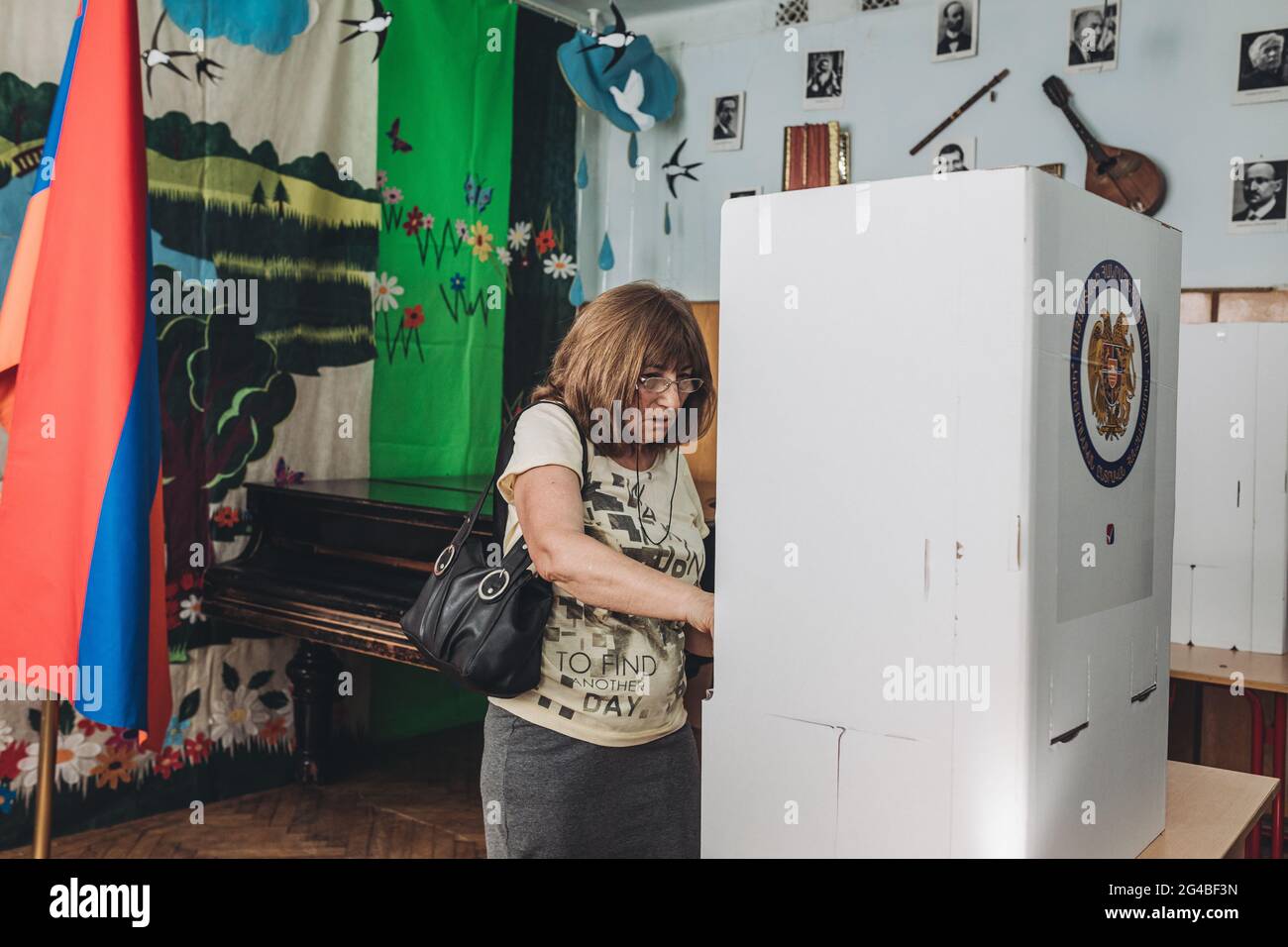 Yerevan, Armenia. 20th June, 2021. A voter casts her vote at a polling ...