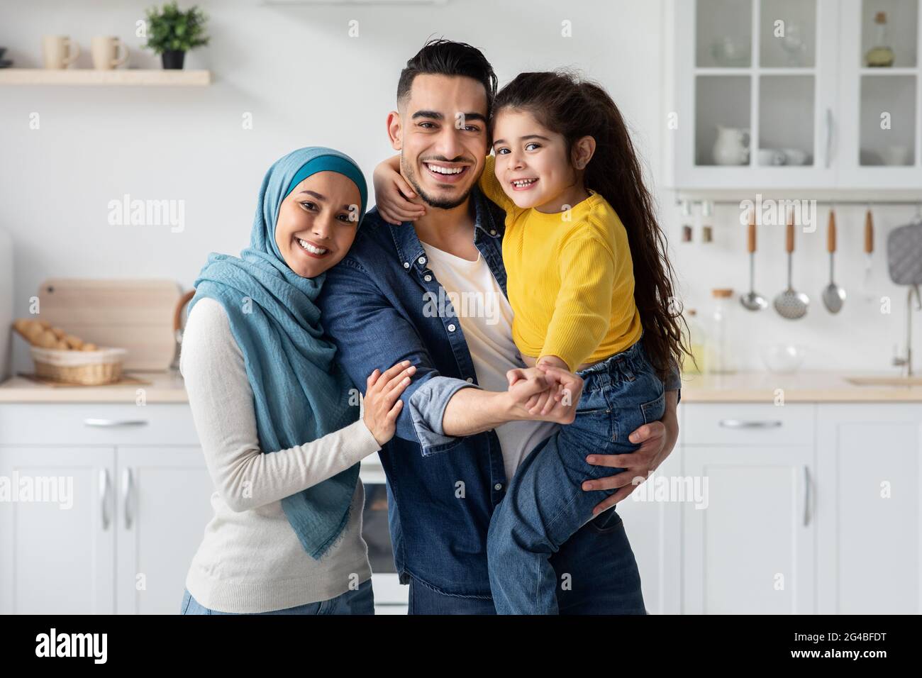 Happy Muslim Parents And Their Little Daughter Posing In Kitchen ...