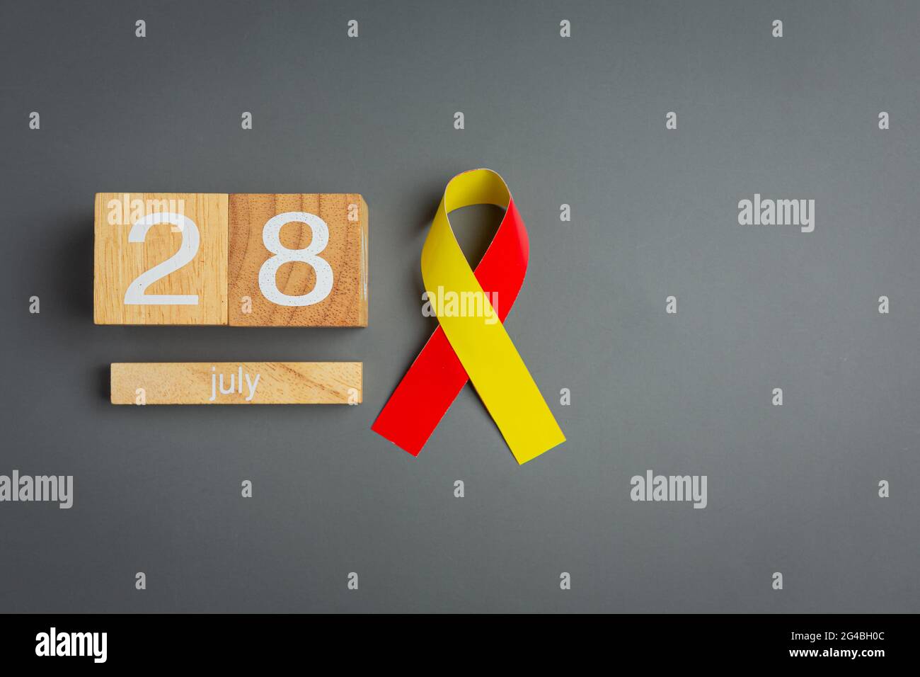 World hepatitis day awareness with red yellow ribbon Stock Photo - Alamy