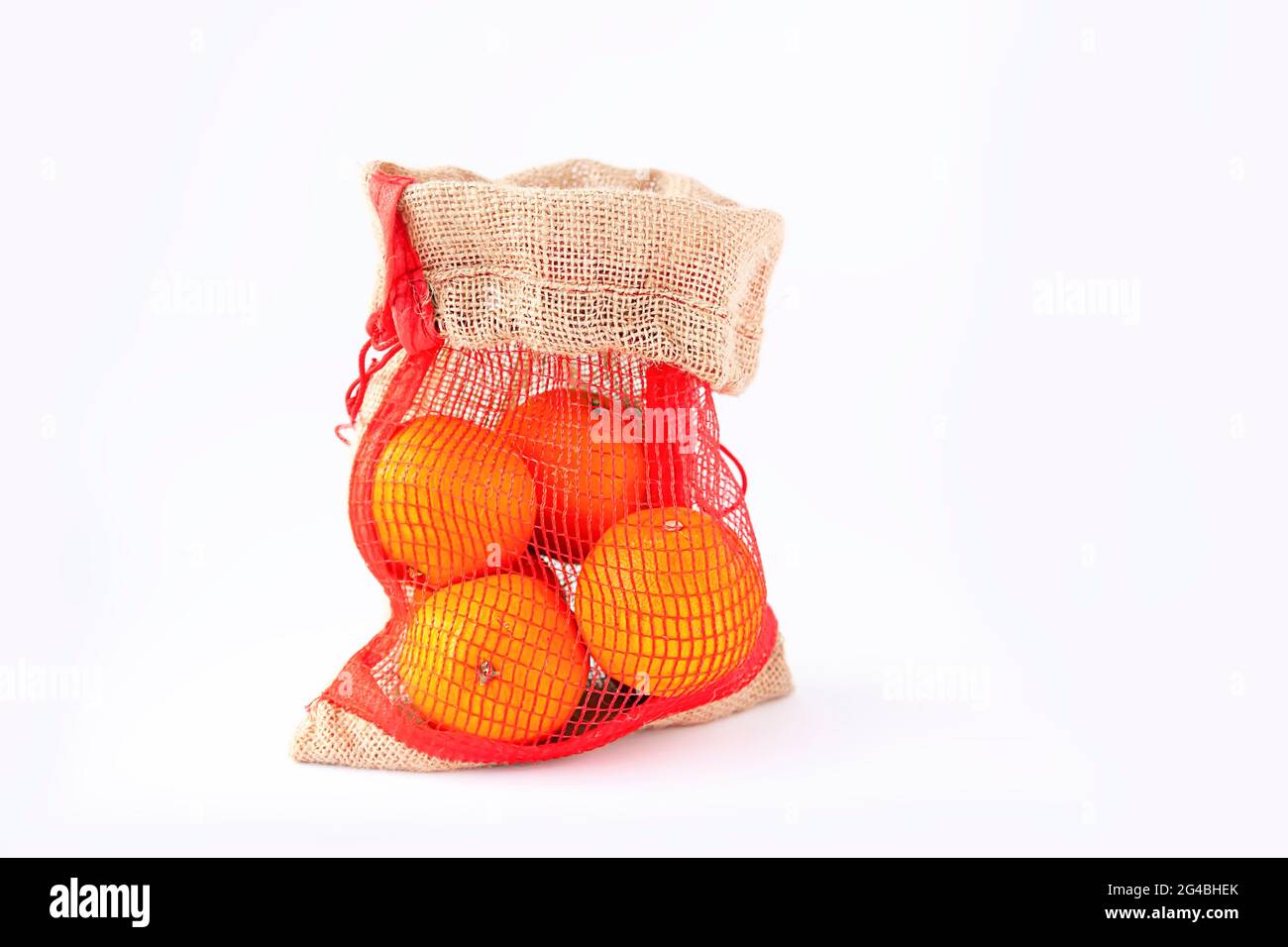 Fresh orange fruits in a burlap bag on white background Stock Photo - Alamy