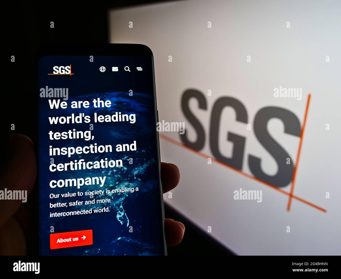 Person holding cellphone with website of Swiss certification company ...