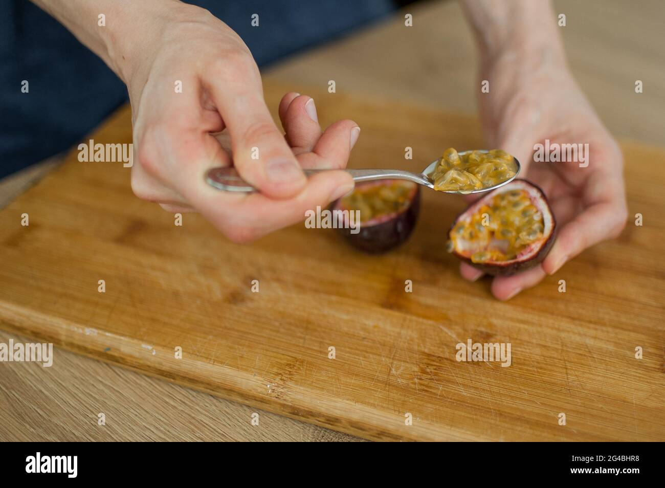 Female eats fresh organic ripe granadilla or yellow passion fruit with ...