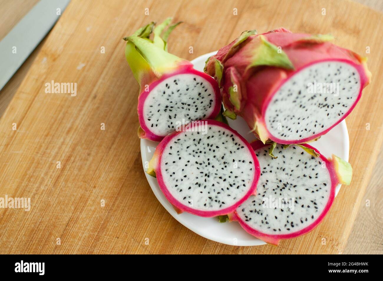 Slices of dragon fruit or pitaya with pink skin and white pulp with ...