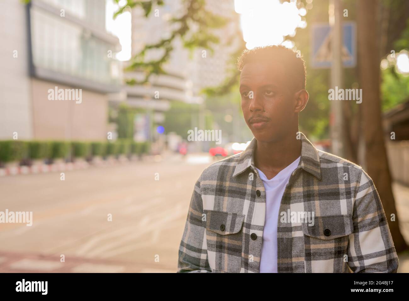 Portrait of African black man outdoors in city thinking during summer ...