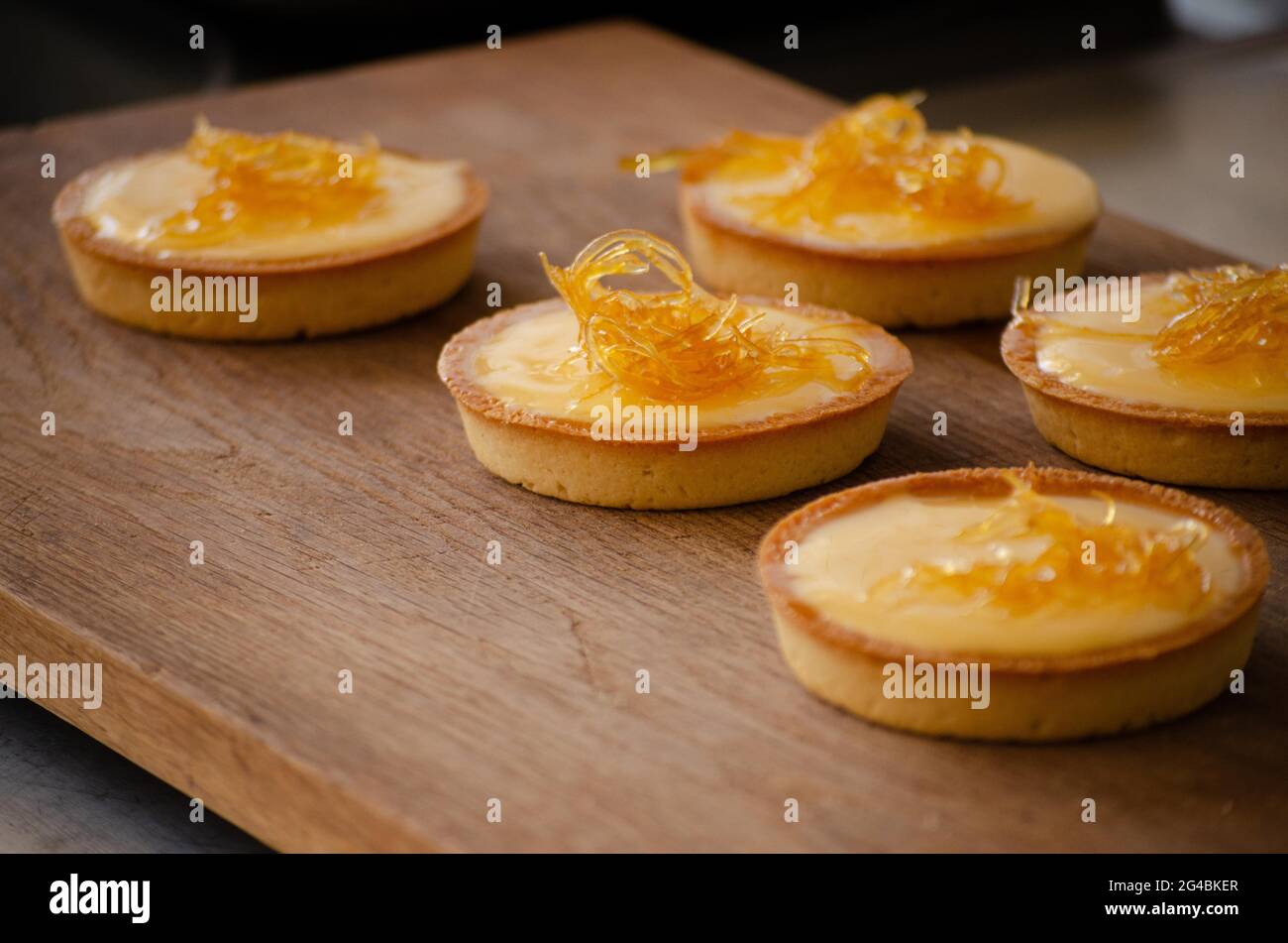 A closeup shot of sweet lemon tarts on a wooden cutting board Stock ...