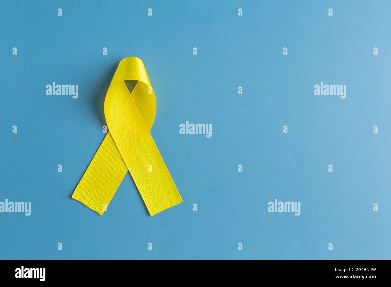 Yellow ribbon on colored background. Cancer concept.Suicide prevention ...