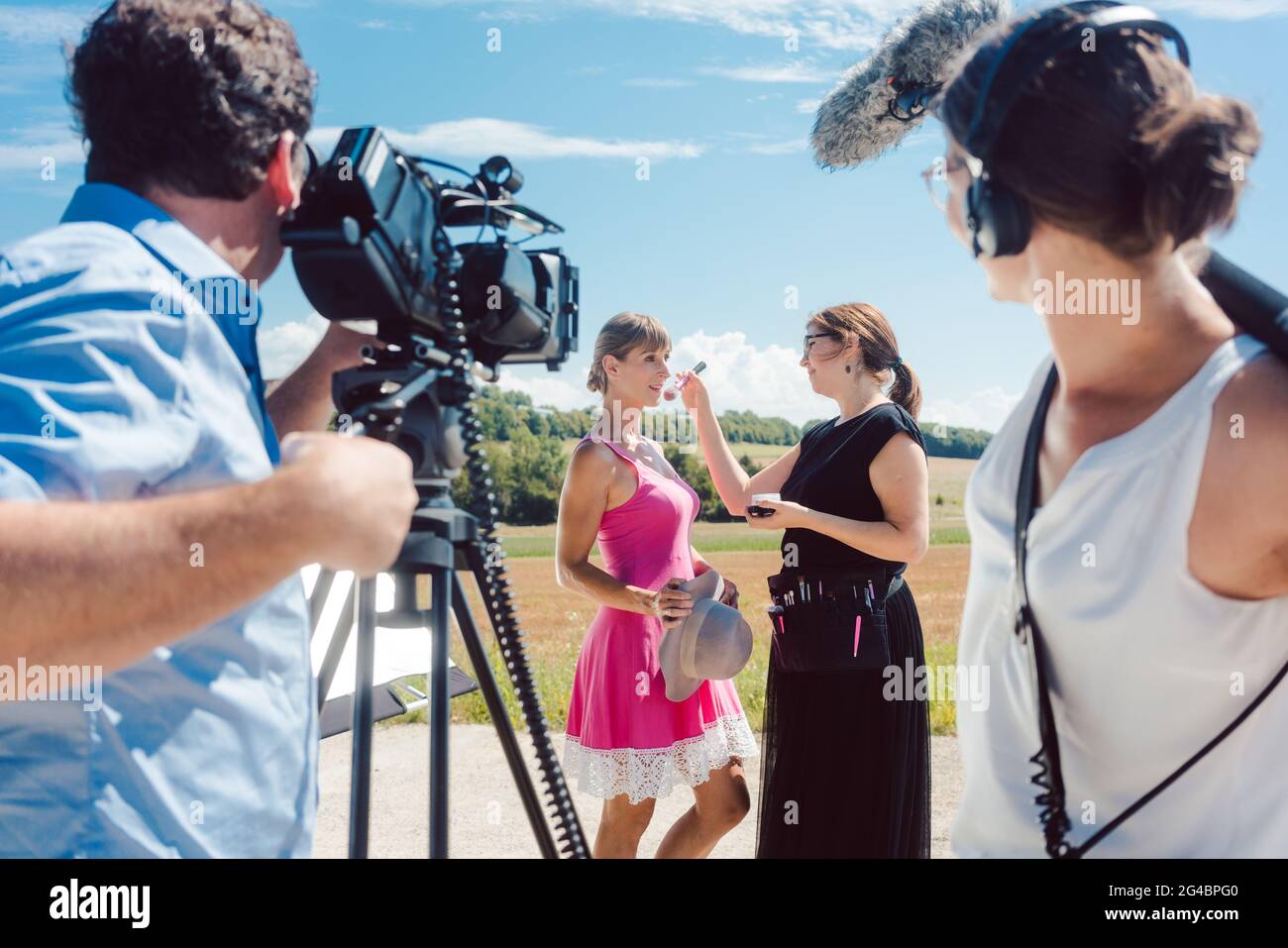 Video shoot with crew, make up artist, and model Stock Photo - Alamy