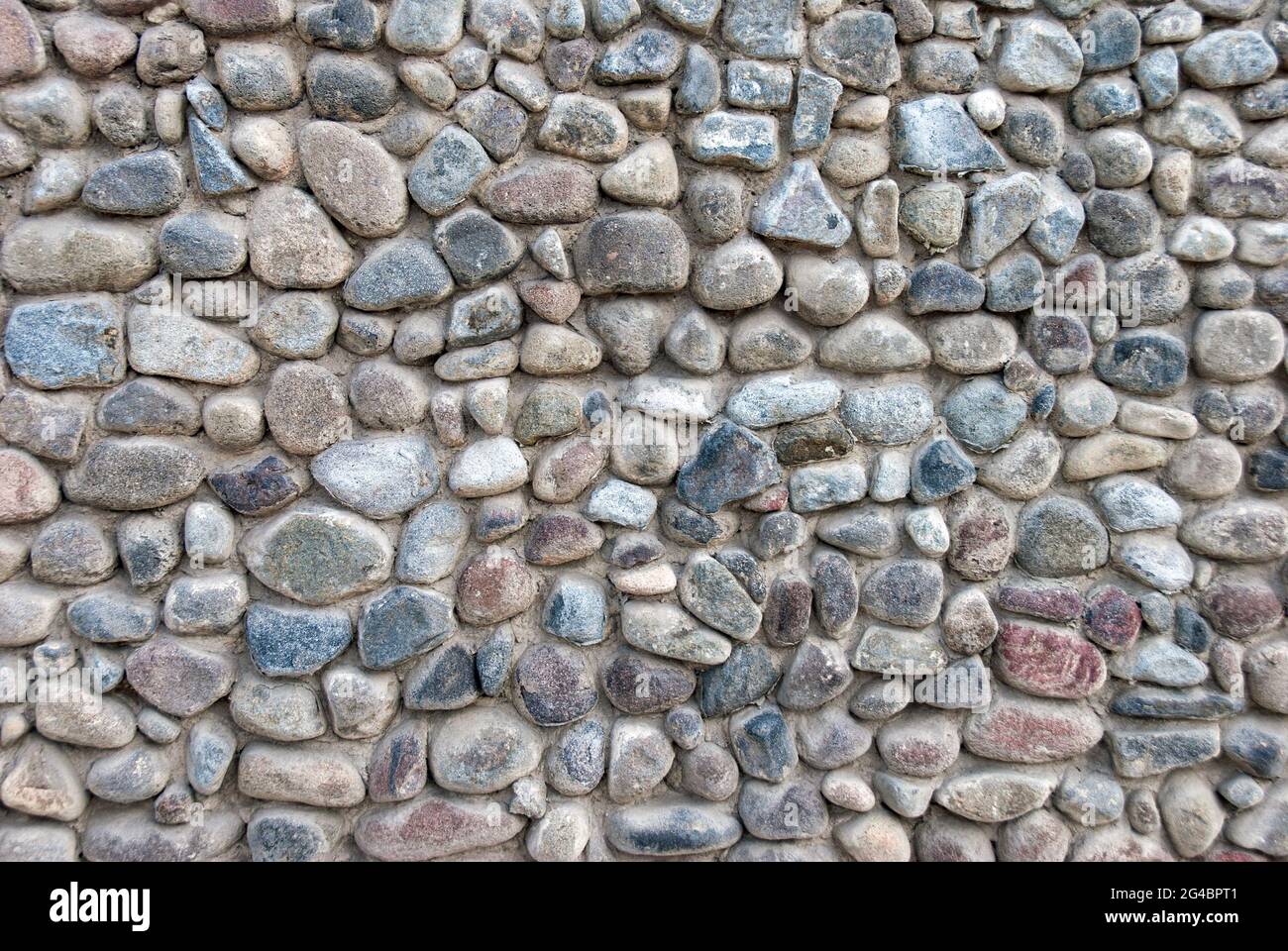 River rocks of different sizes, shapes, and colors are made into a wall ...