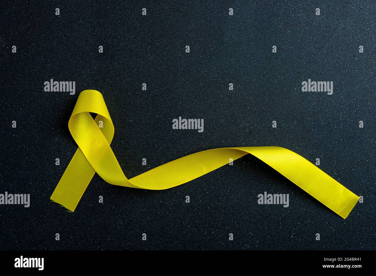 Yellow ribbon on colored background. Cancer concept.Suicide prevention ...