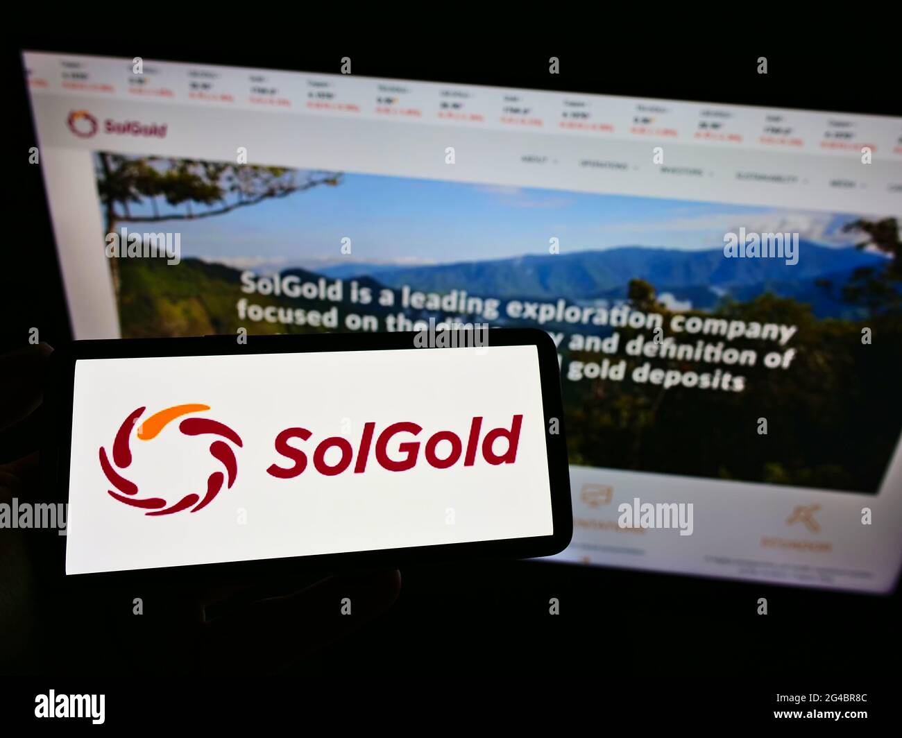 Person holding cellphone with logo of Australian mining company SolGold ...