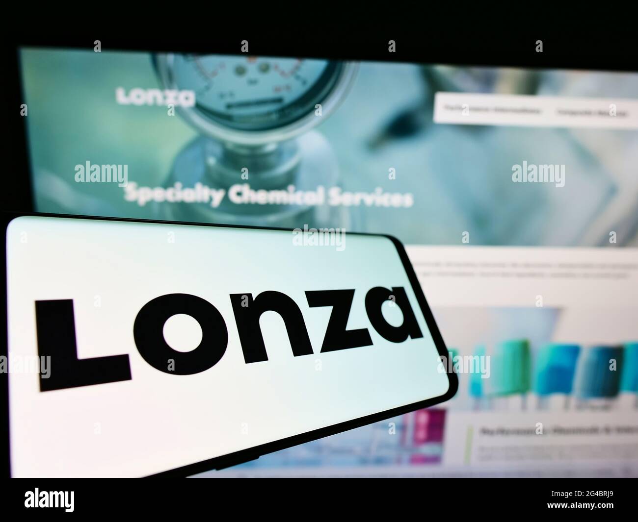 Smartphone with business logo of Swiss chemical company Lonza Group AG on screen in front of ...