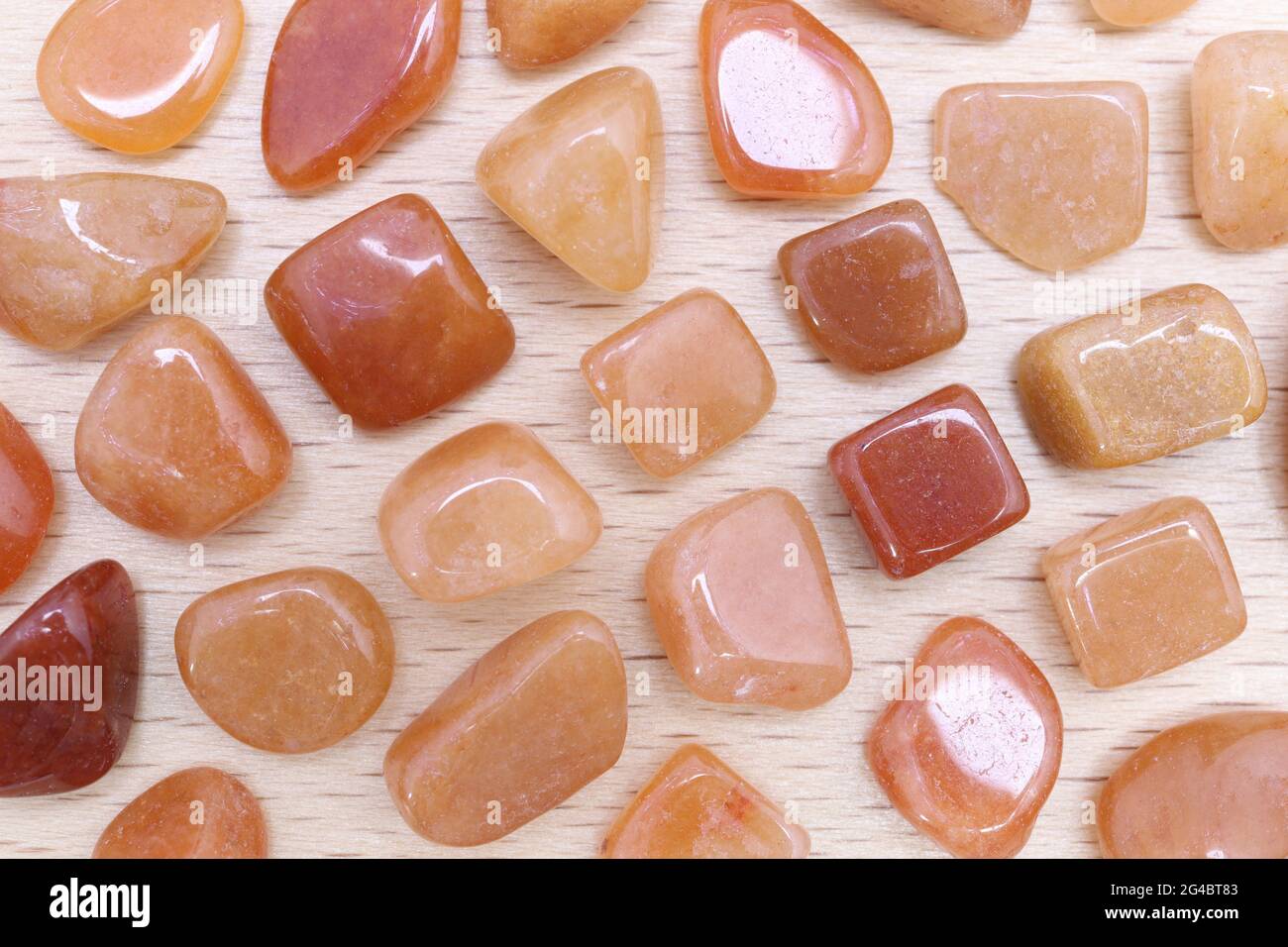 Red Aventurine rare jewel on light varnished wood texture. Sparse ...