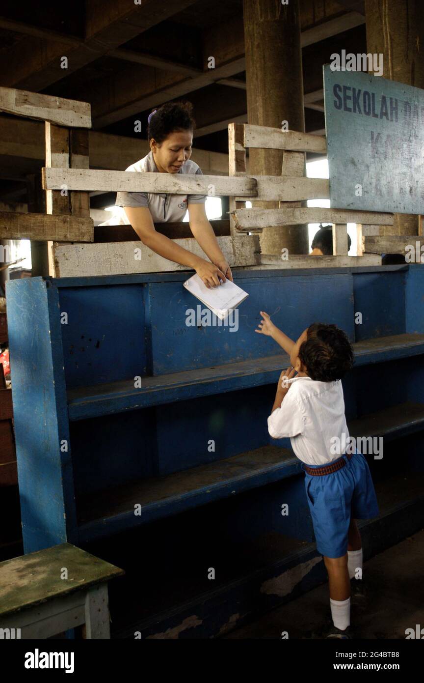 A mother helps her child during the class at emergency school under the ...