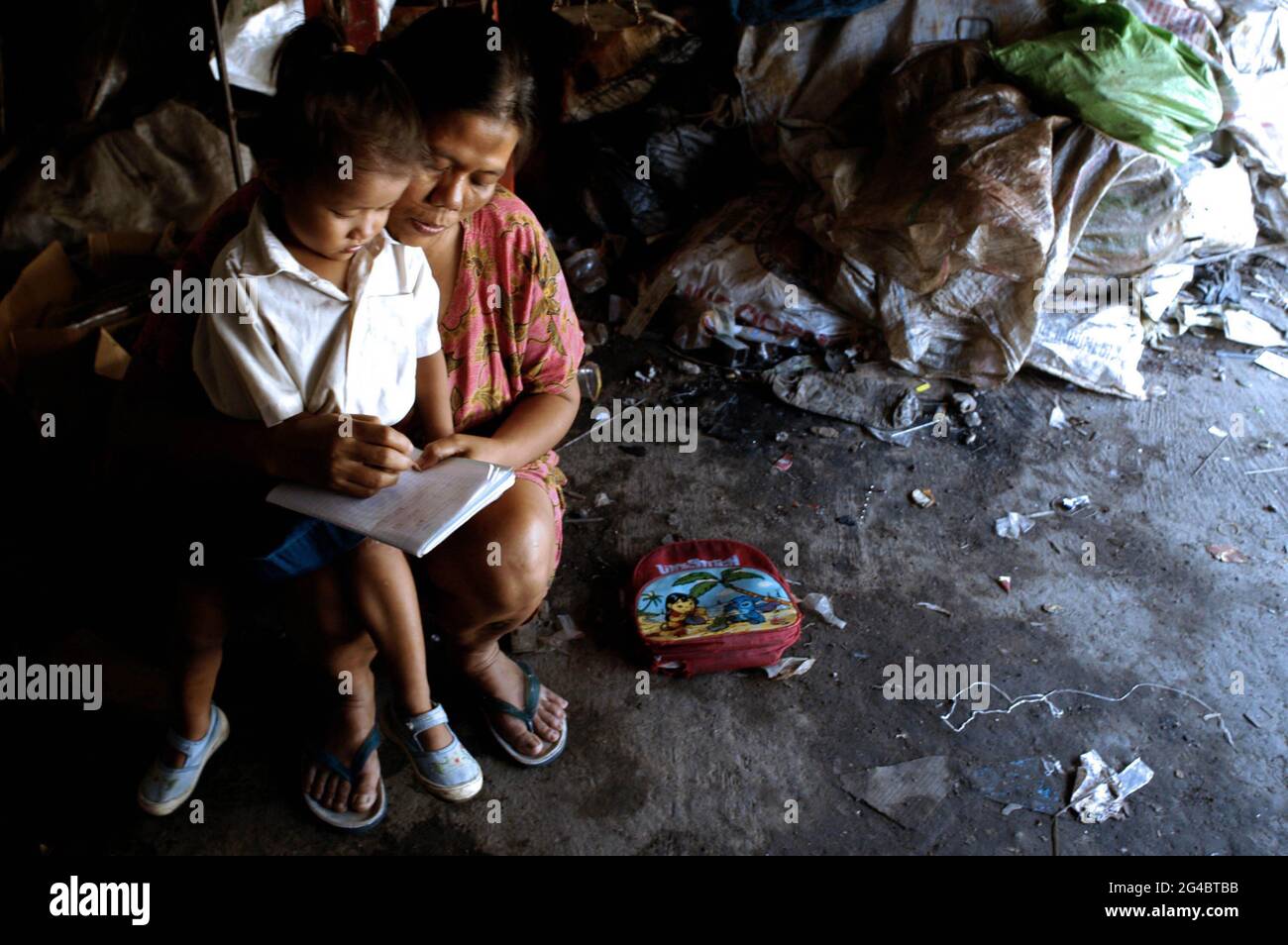 A mother helps her child during the class at emergency school under the ...
