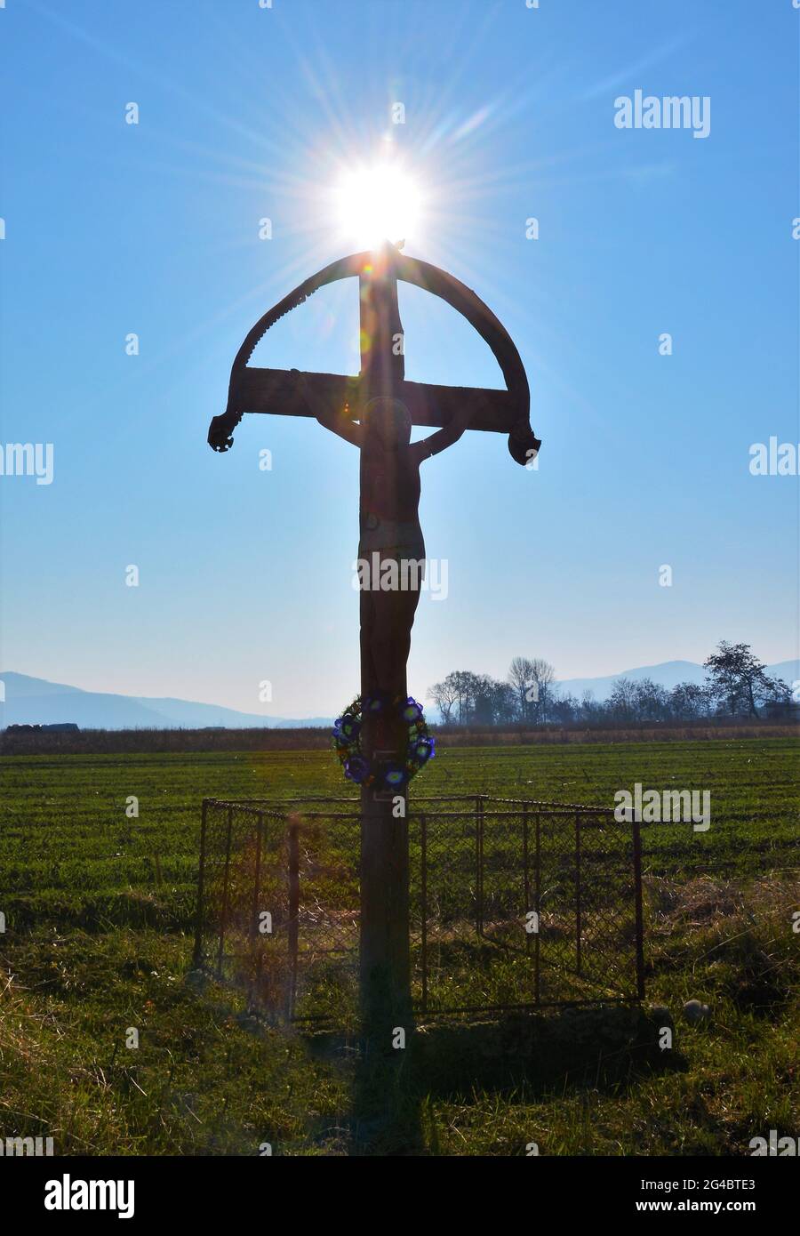 a vertical shot of the sun just above the jesus crucifixion landmark in ...